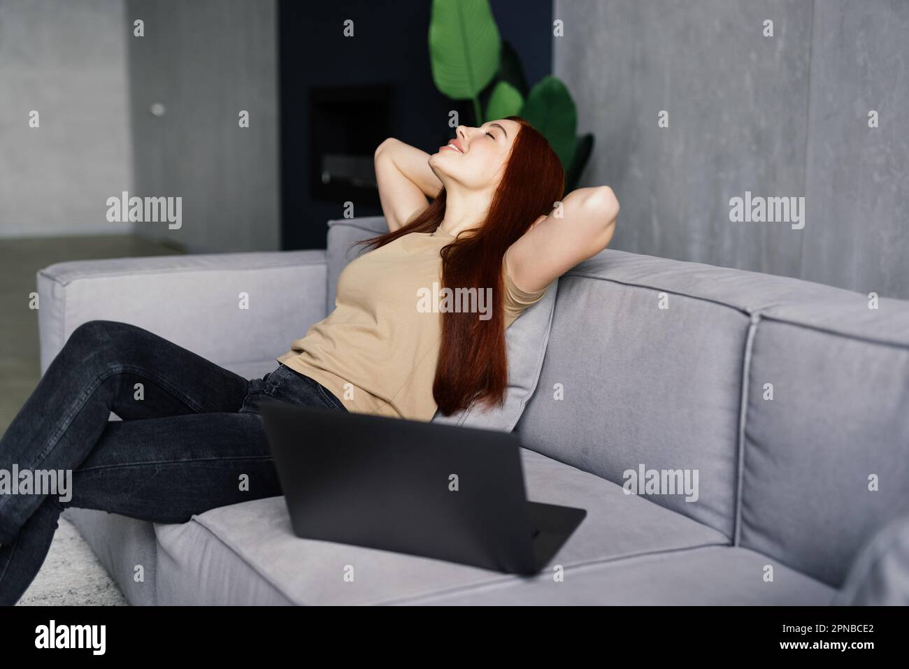 Finally weekends. Millennial girl relaxing at home on couch, enjoying ...