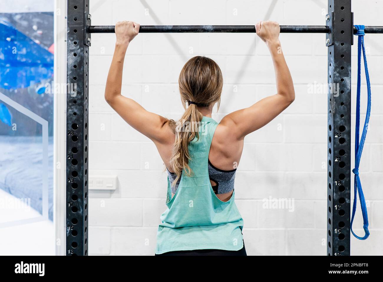 Back view of unrecognizable strong female athlete in sportswear doing ...
