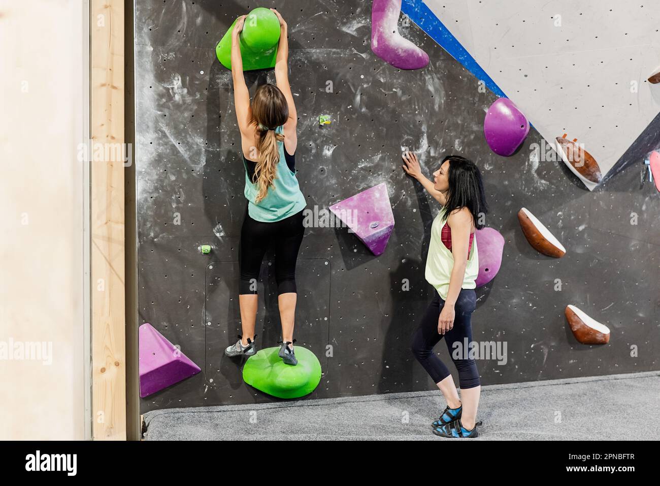Back view of unrecognizable female alpinist in sportswear climbing ...