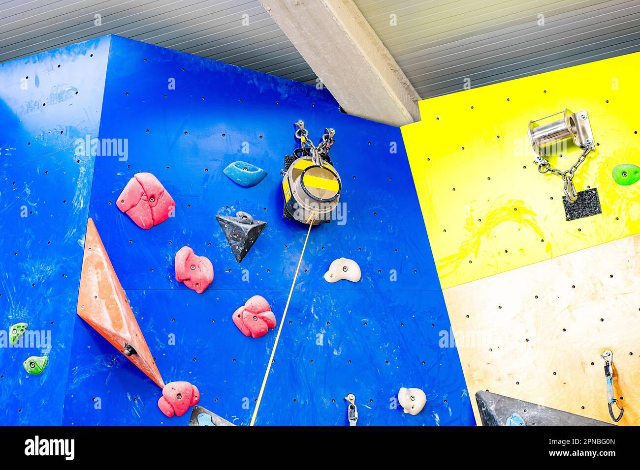 From below of yellow and blue wall with climbing holds in modern ...