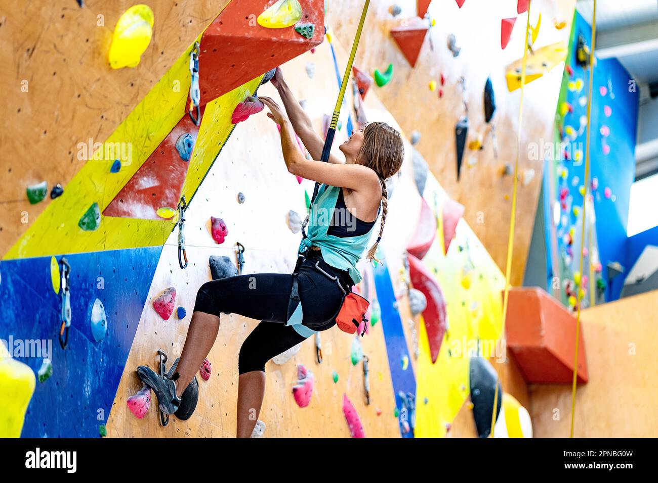 From below side view of female with shoes holding on to holds while ...