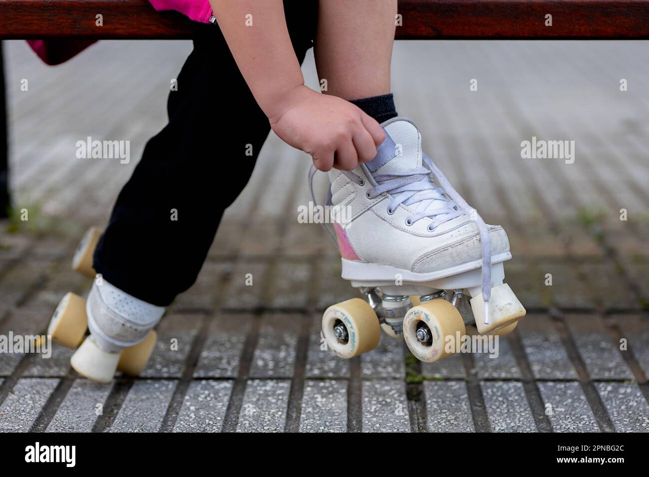 From above of anonymous person skater sitting on bench on pavement and ...