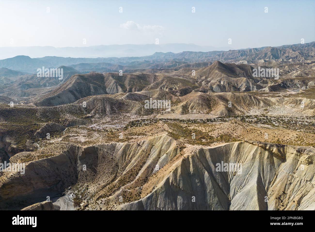 Aerial view of rough rocky mountains with dry river meandering through ...