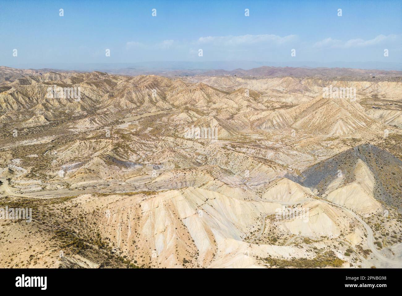 Aerial view of rough rocky mountains with dry river meandering through ...