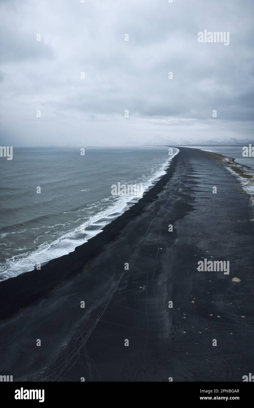 Aerial view of wavy ocean with foamy water washing muddy beach under ...