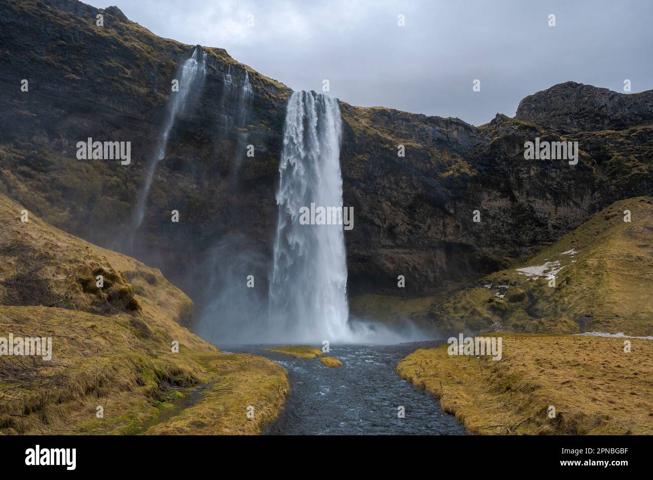 Scenic view of Seljalandsfoss waterfall falling from rough rocky cliff ...
