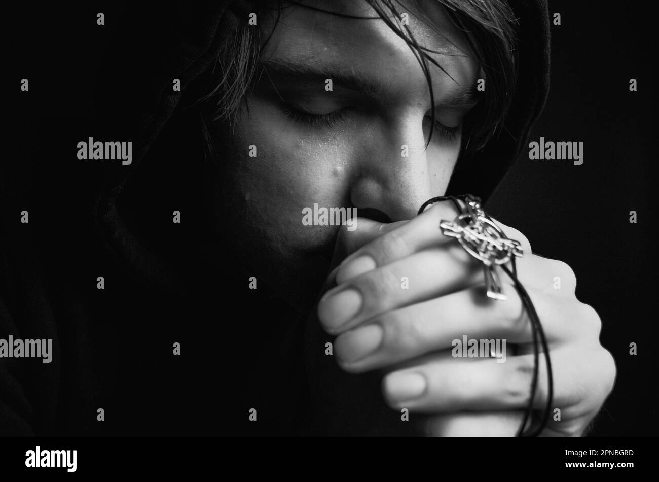 Handsome young man praying in Black and White Stock Photos & Images - Alamy