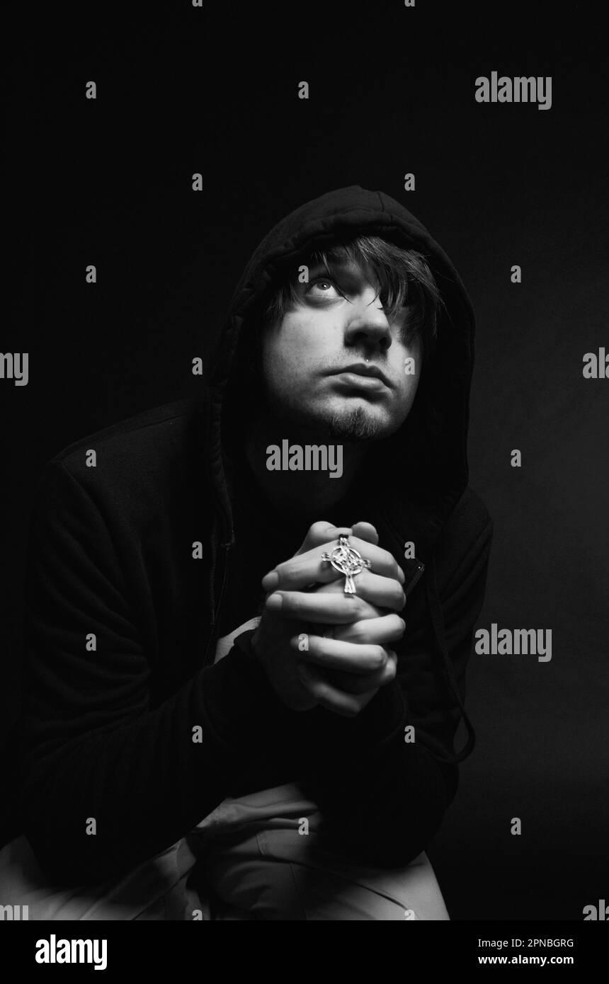 Handsome young man praying in Black and White Stock Photos & Images - Alamy
