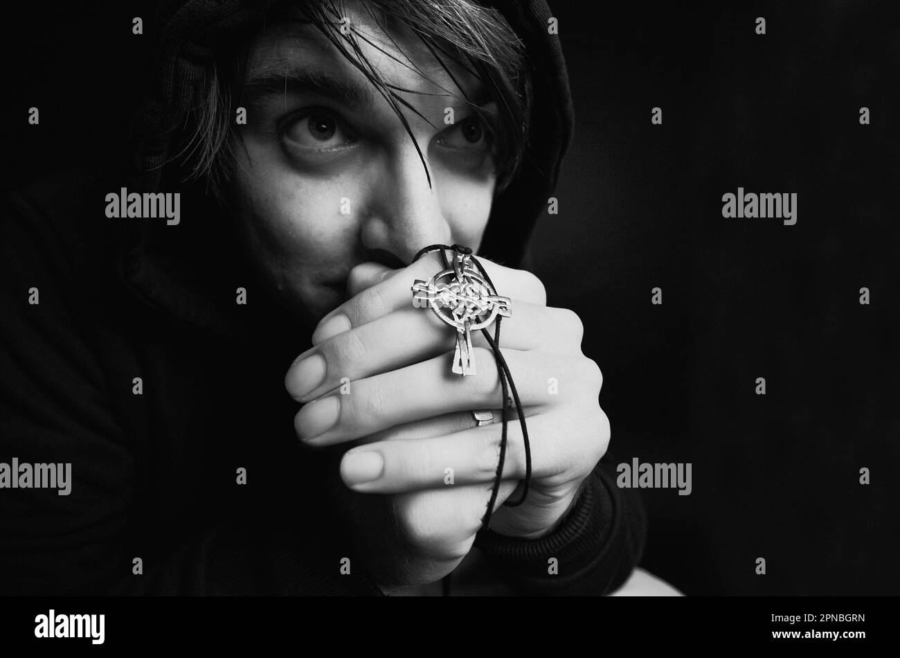 Praying man on black Black and White Stock Photos & Images - Alamy