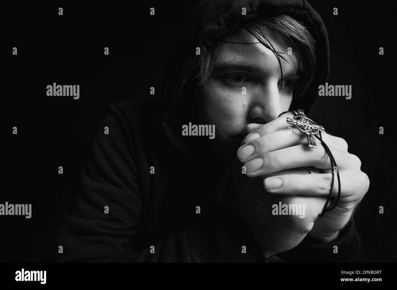 Handsome young man praying in Black and White Stock Photos & Images - Alamy