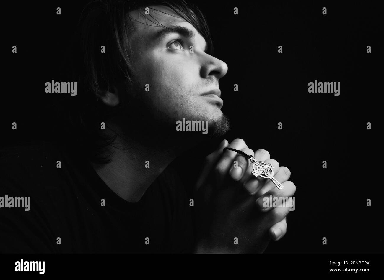 Handsome young man praying in Black and White Stock Photos & Images - Alamy