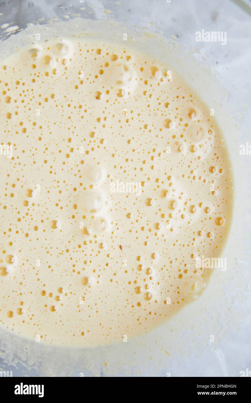 Top view of beaten egg whites in bowl placed on marble table during ...