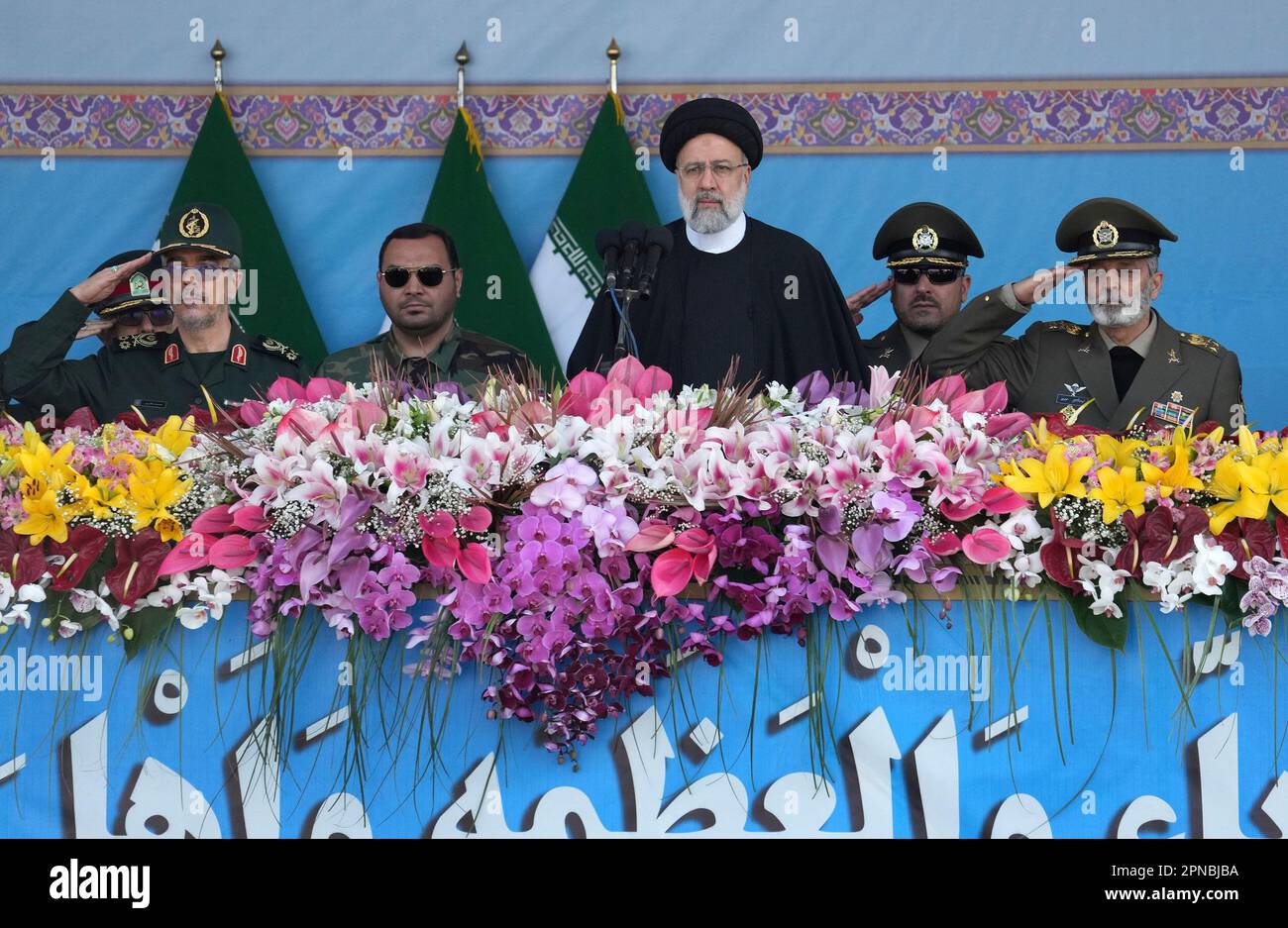 Iranian President Ebrahim Raisi, center, listens to the national anthem ...