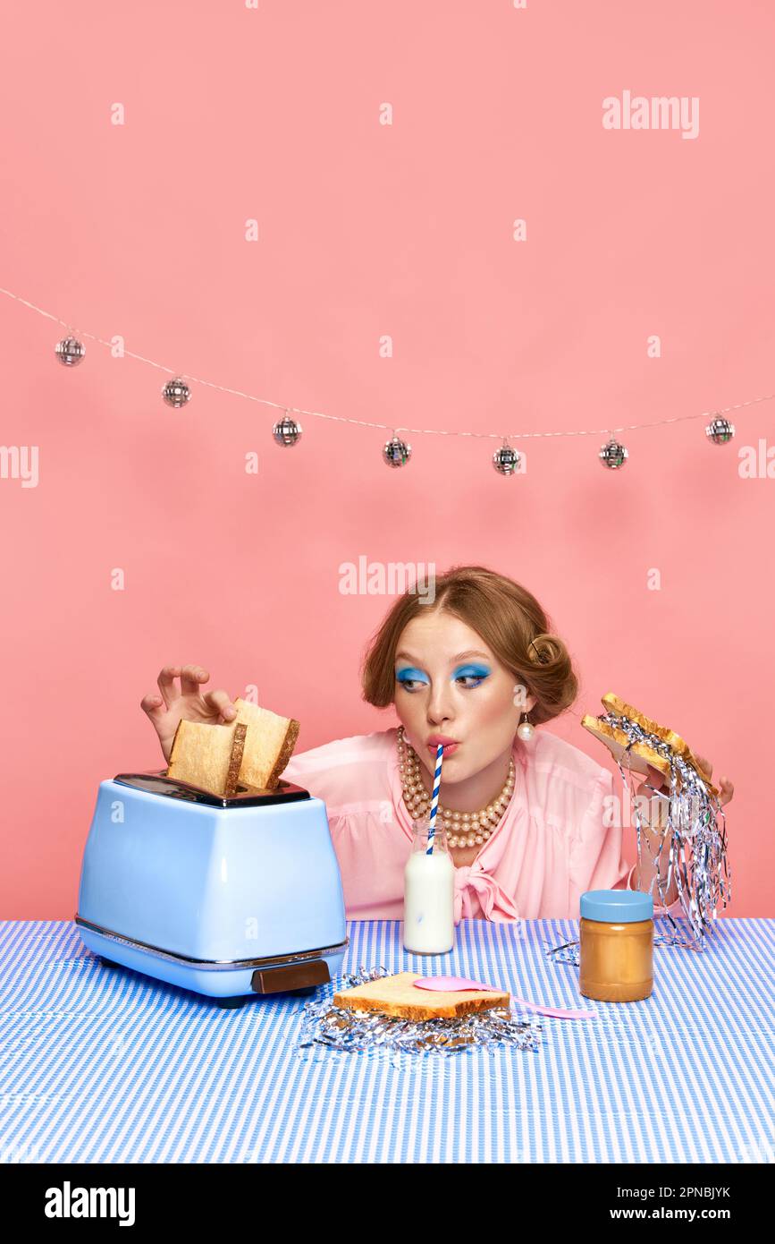 Beautiful young girl with bright makeup drinking milk, eating toast ...