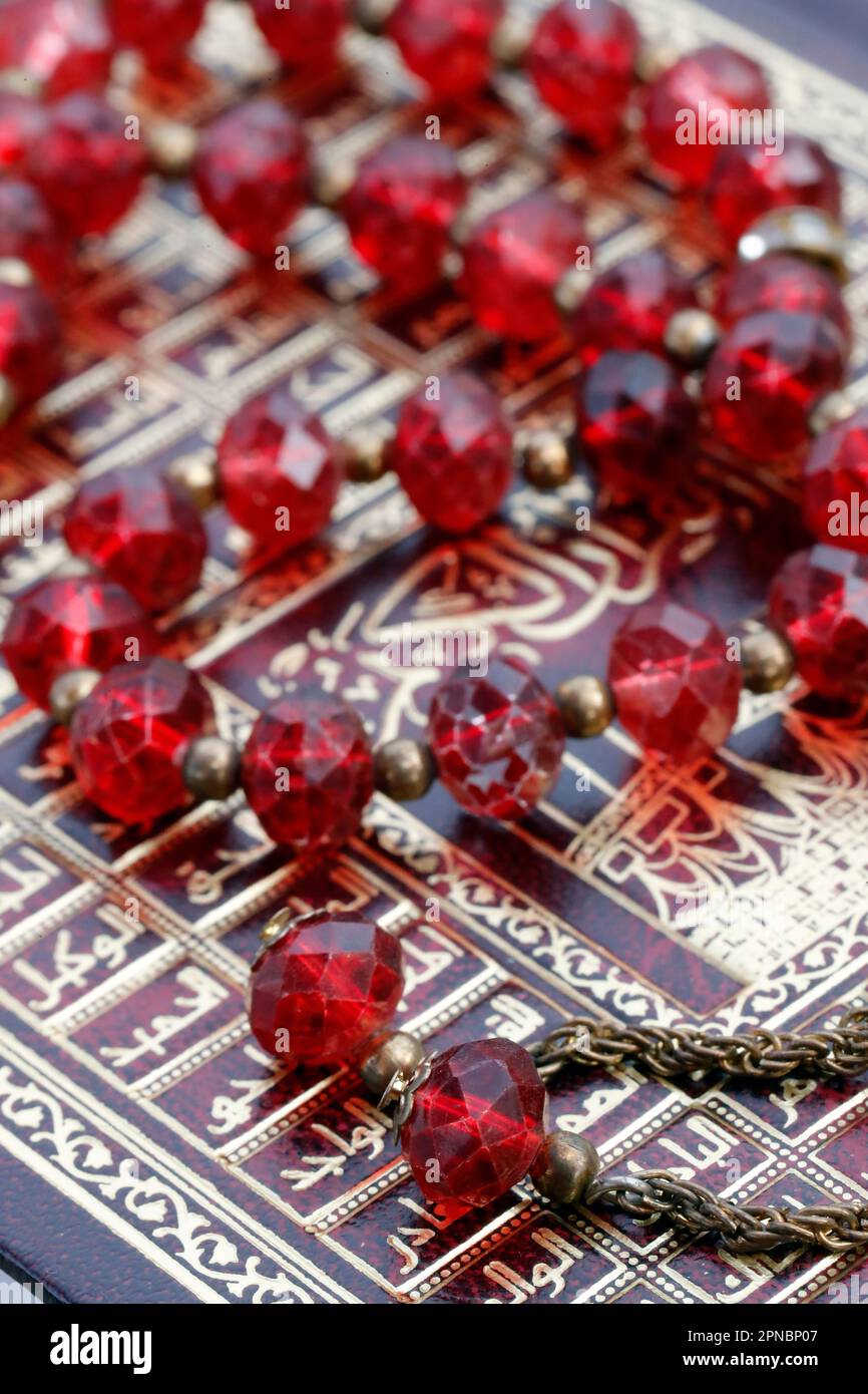 Prayer beads and the cover of the Holy Quran (Koran) with the 99 names ...