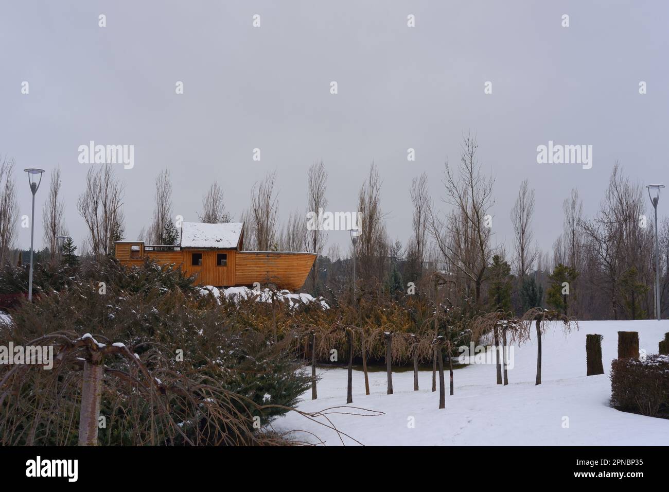 Smaal wooden boat under snow between bushes and trees Stock Photo - Alamy