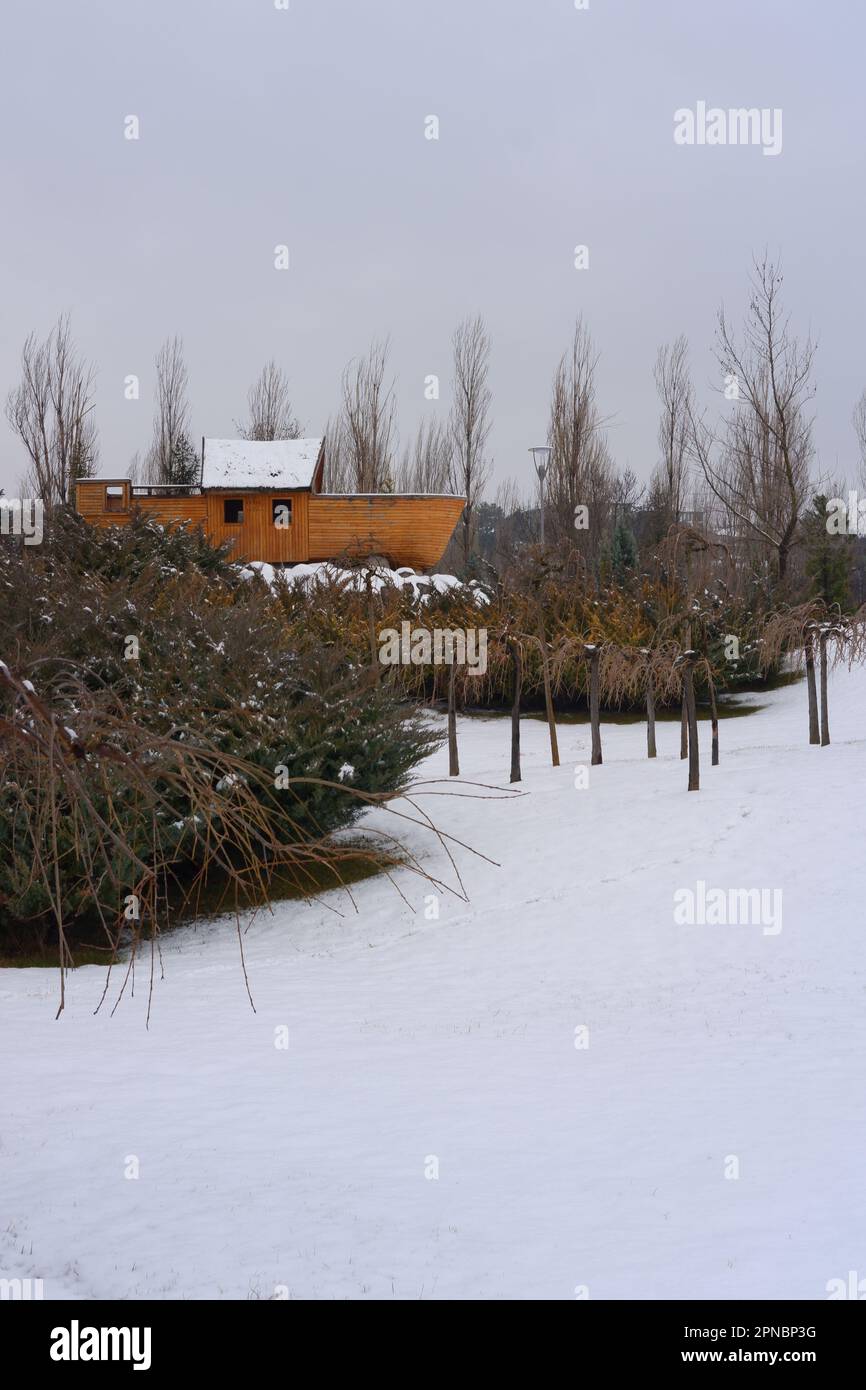 Smaal wooden boat under snow between bushes and trees Stock Photo - Alamy