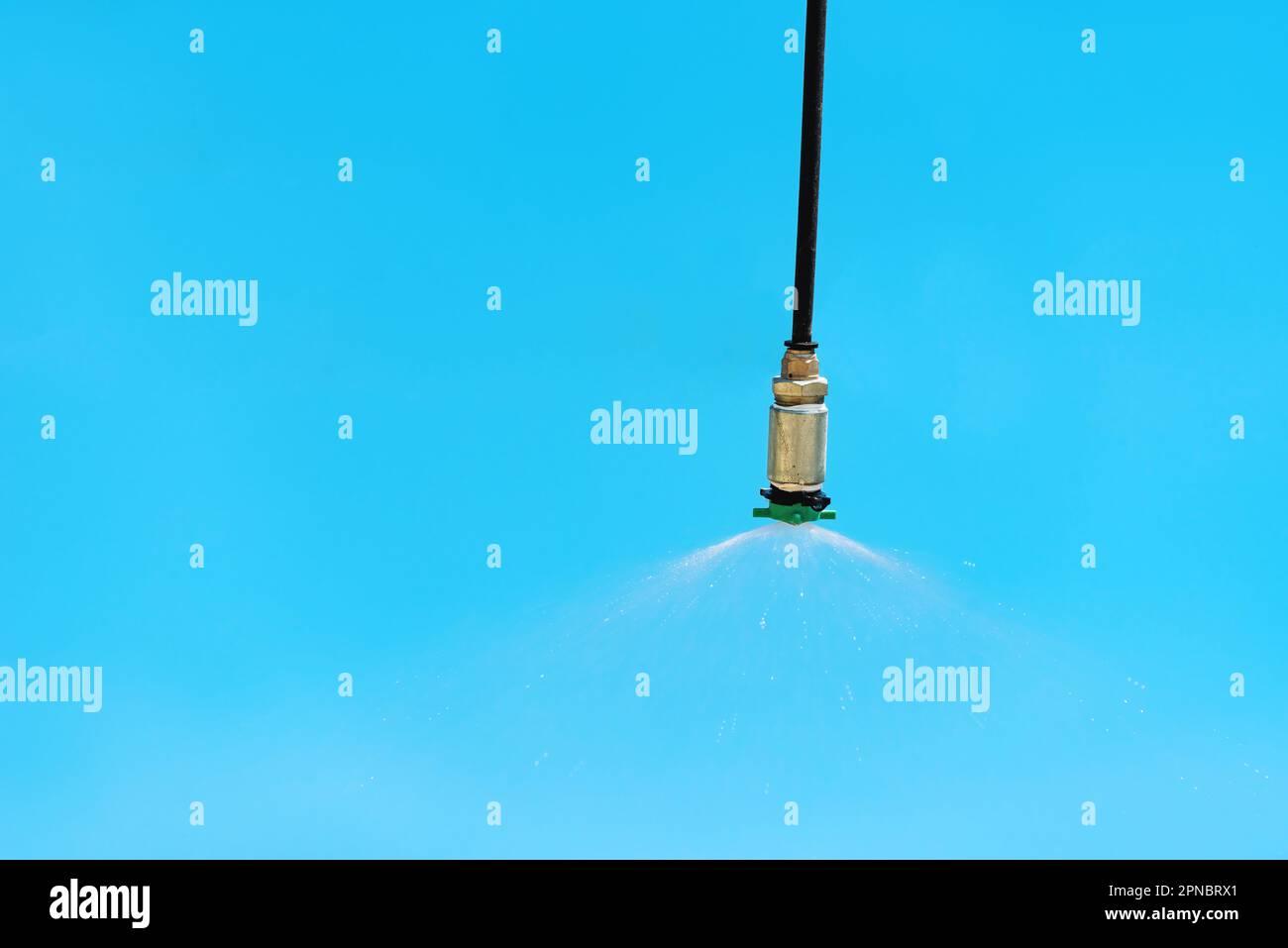 Agricultural sprinkler spraying the water drops over crops in ...