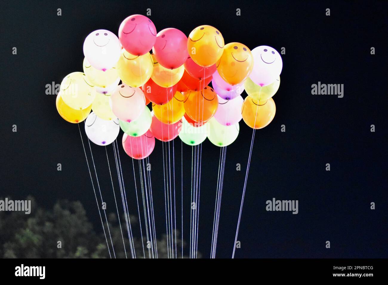 A group of colorful Smiley Balloons tied together into a bunch for sale ...