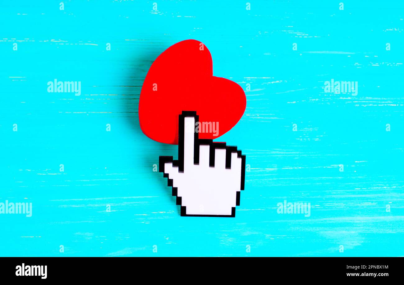 Plastic pointer cursor touches a red heart shape isolated on vibrant ...