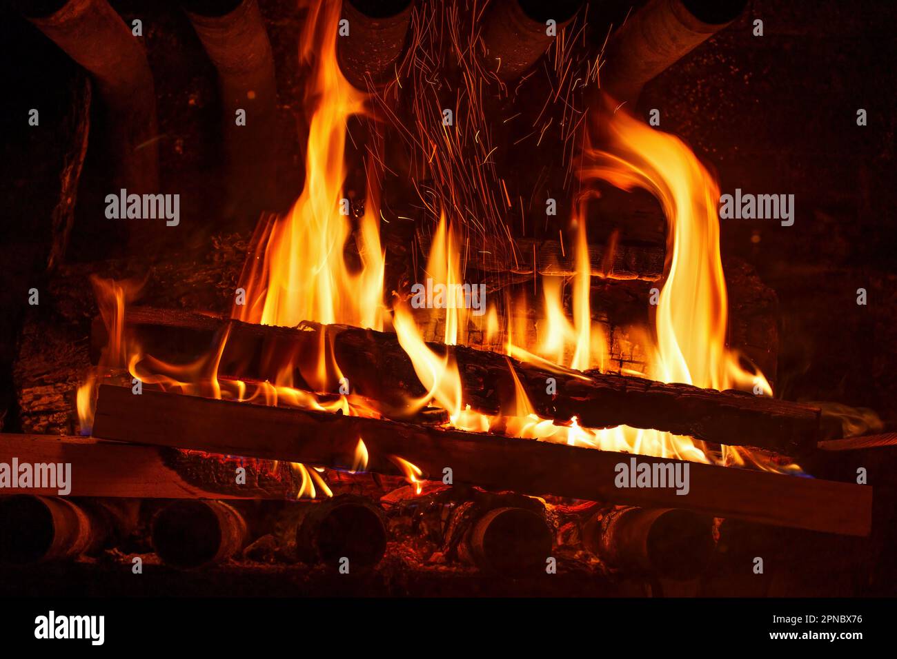 A roaring close-up of a burning fireplace, with dancing flames heating ...