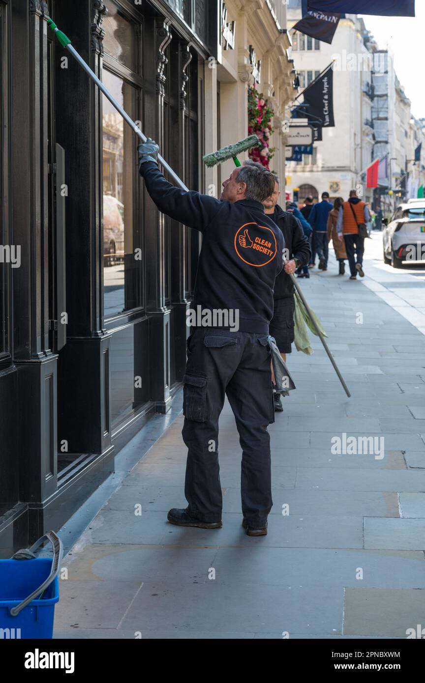 Window cleaners working on a shopfront, New Bond Street, Mayfair ...