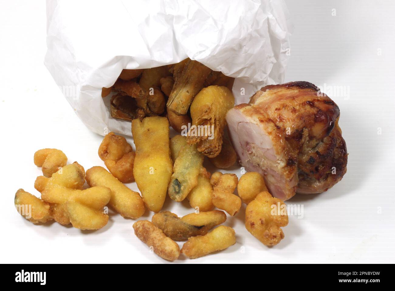 The mixed chicken kebabs with fried battered vegetables against a white ...