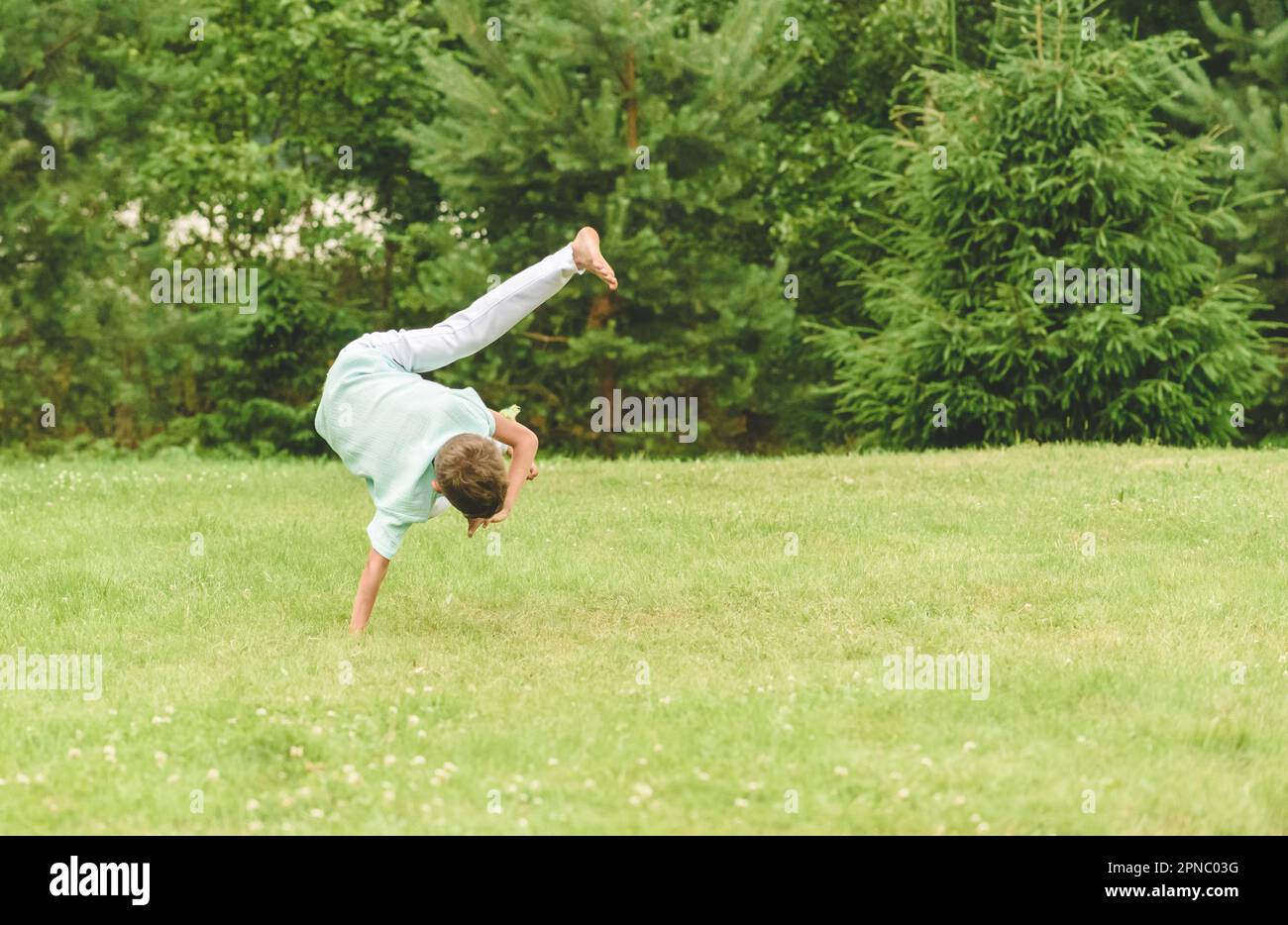 Kid doing martial art exercise training at home backyard lawn. Boy ...