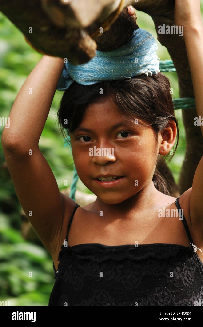 Young girl carries a log balanced on her head inside the Cerro Verde ...