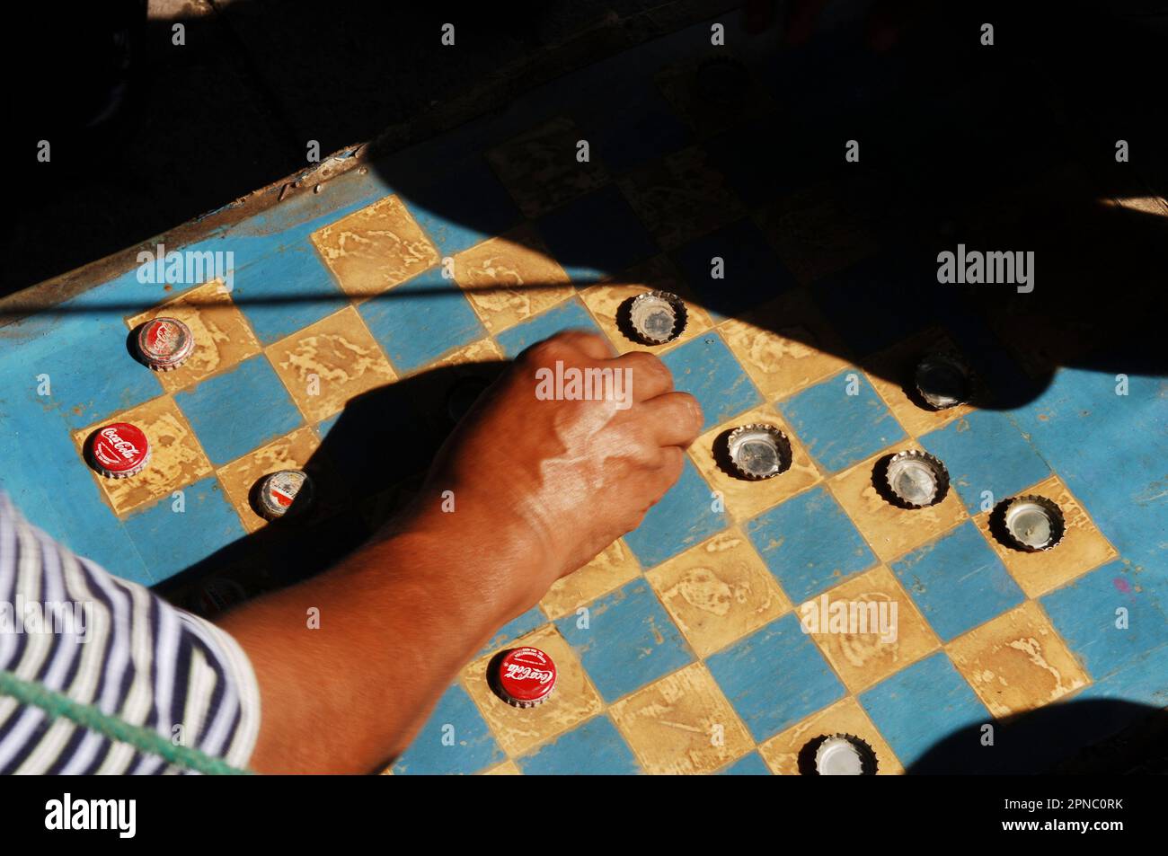 Checkers players with caps of Coca Cola bottles in front of the Church ...