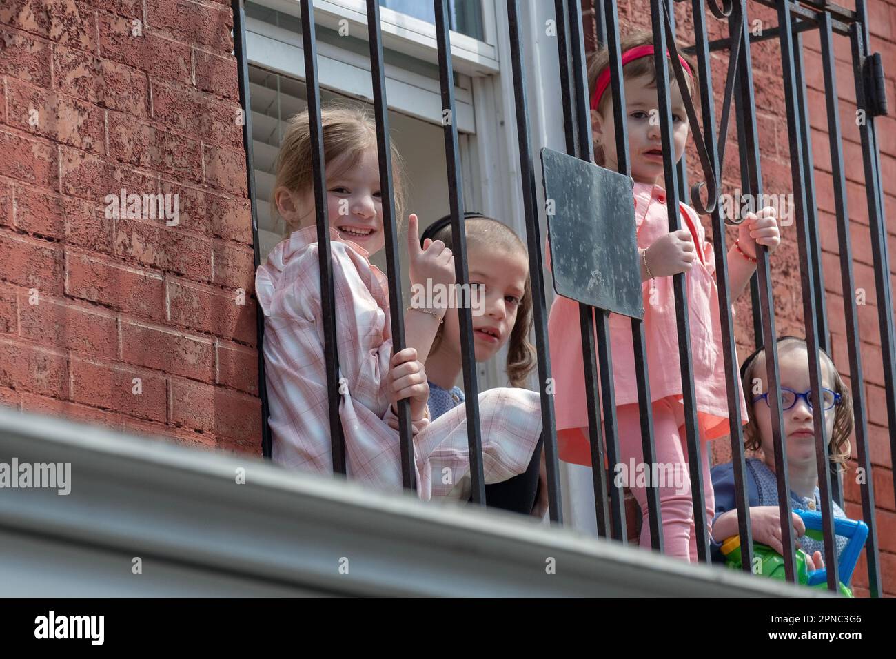 Orthodox Jewish children enjoy a mild spring day on their fire escape ...