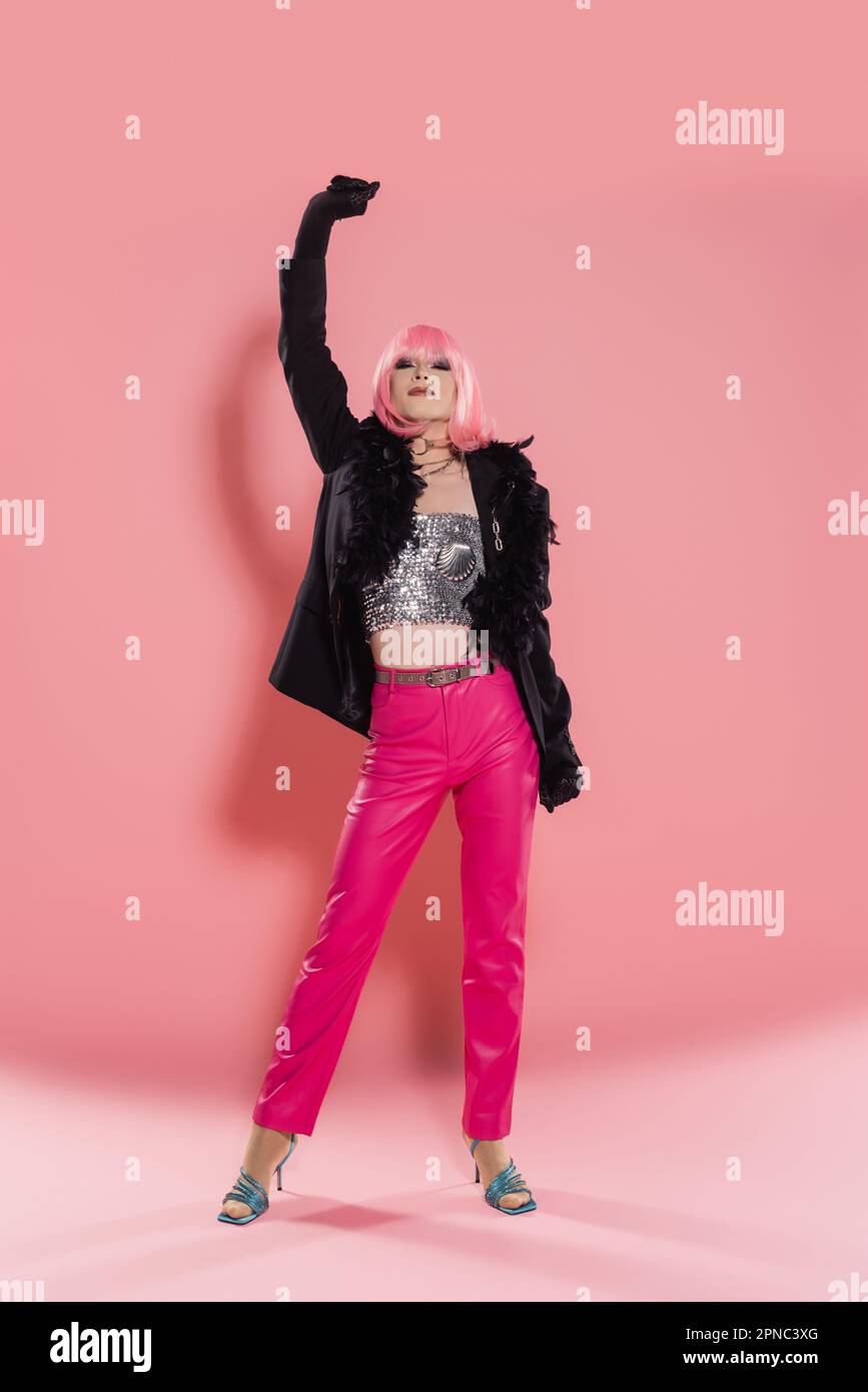 Full length of stylish drag queen in jacket with feathers posing on ...
