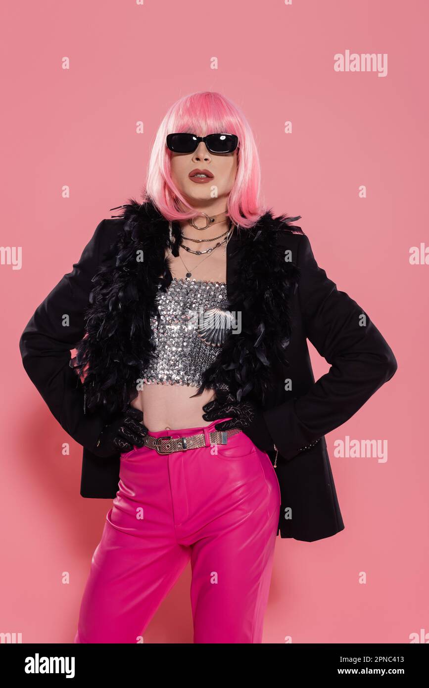 Portrait of drag queen in sparkling top and jacket with feathers posing ...
