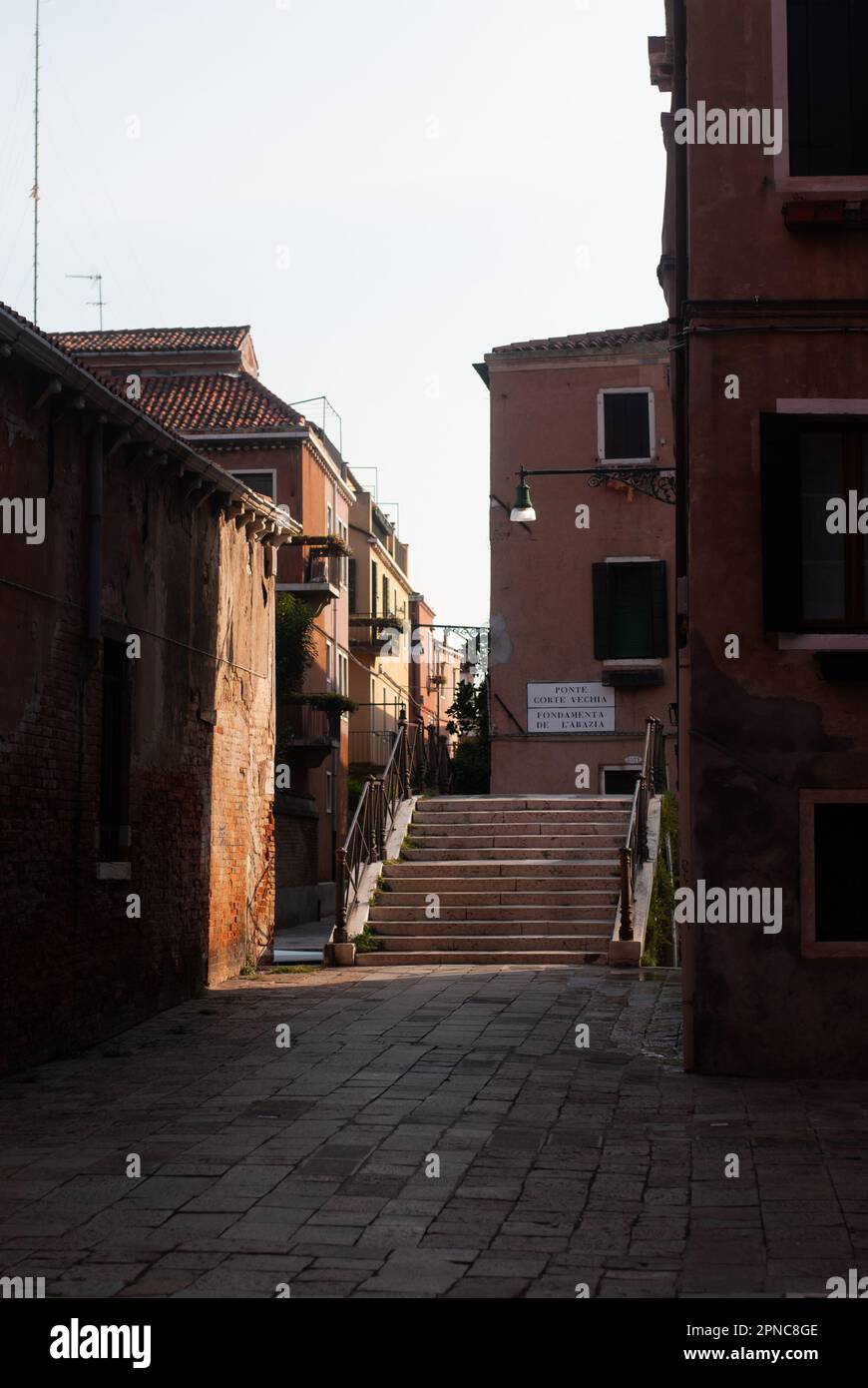 View of street with stairs in sun rays Stock Photo - Alamy