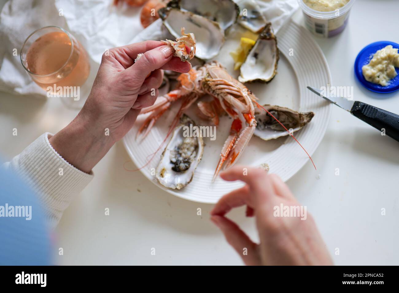 Woman cleaning prawns above table full of fresh seafood with oyster and ...