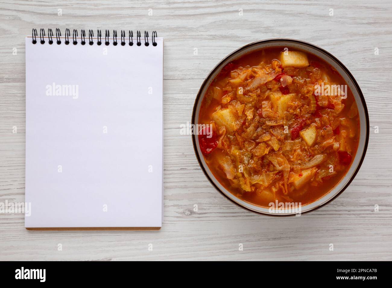 Homemade Shredded Cabbage and Potato Soup in a Bowl, blank notepad, top ...