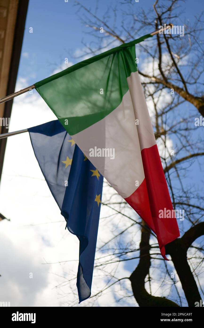 Italian and European flags hanging on flagpoles on building Stock Photo ...