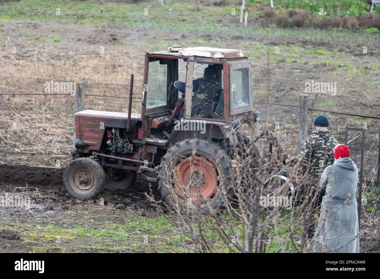 farm tractor with plow plows the field and prepares for sowing Stock ...