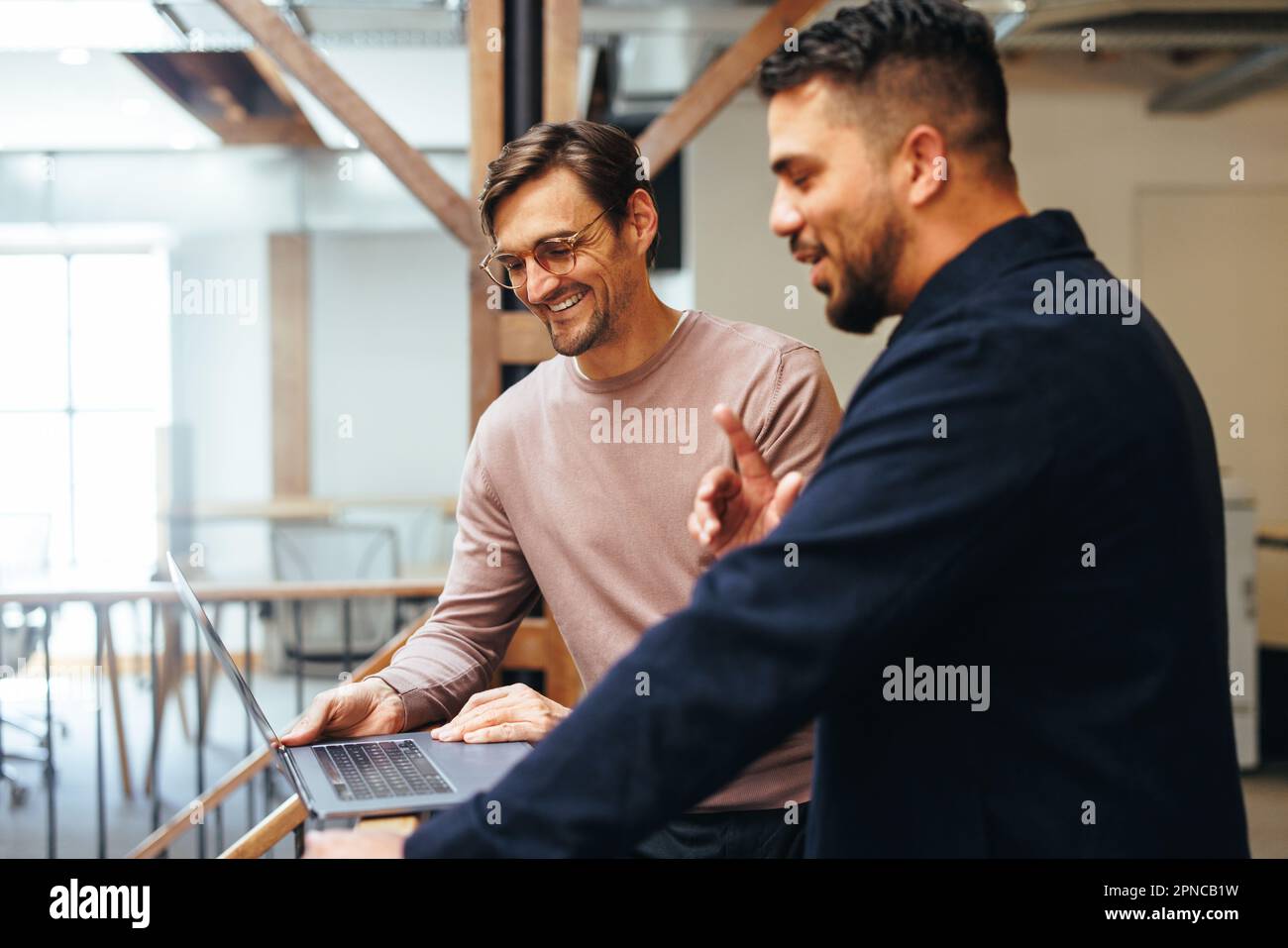 business men video calling their clients on a laptop in an office. Two ...