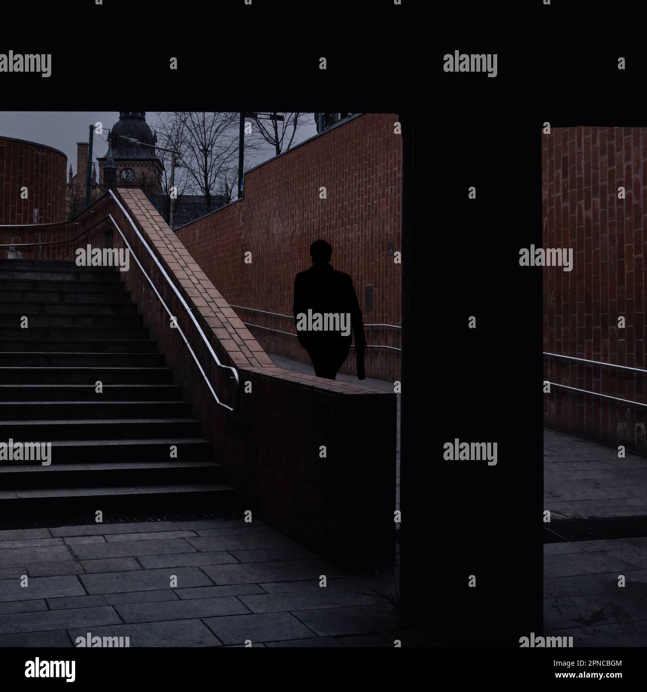 A silhouette of a man walking next to the illuminated stone steps Stock ...