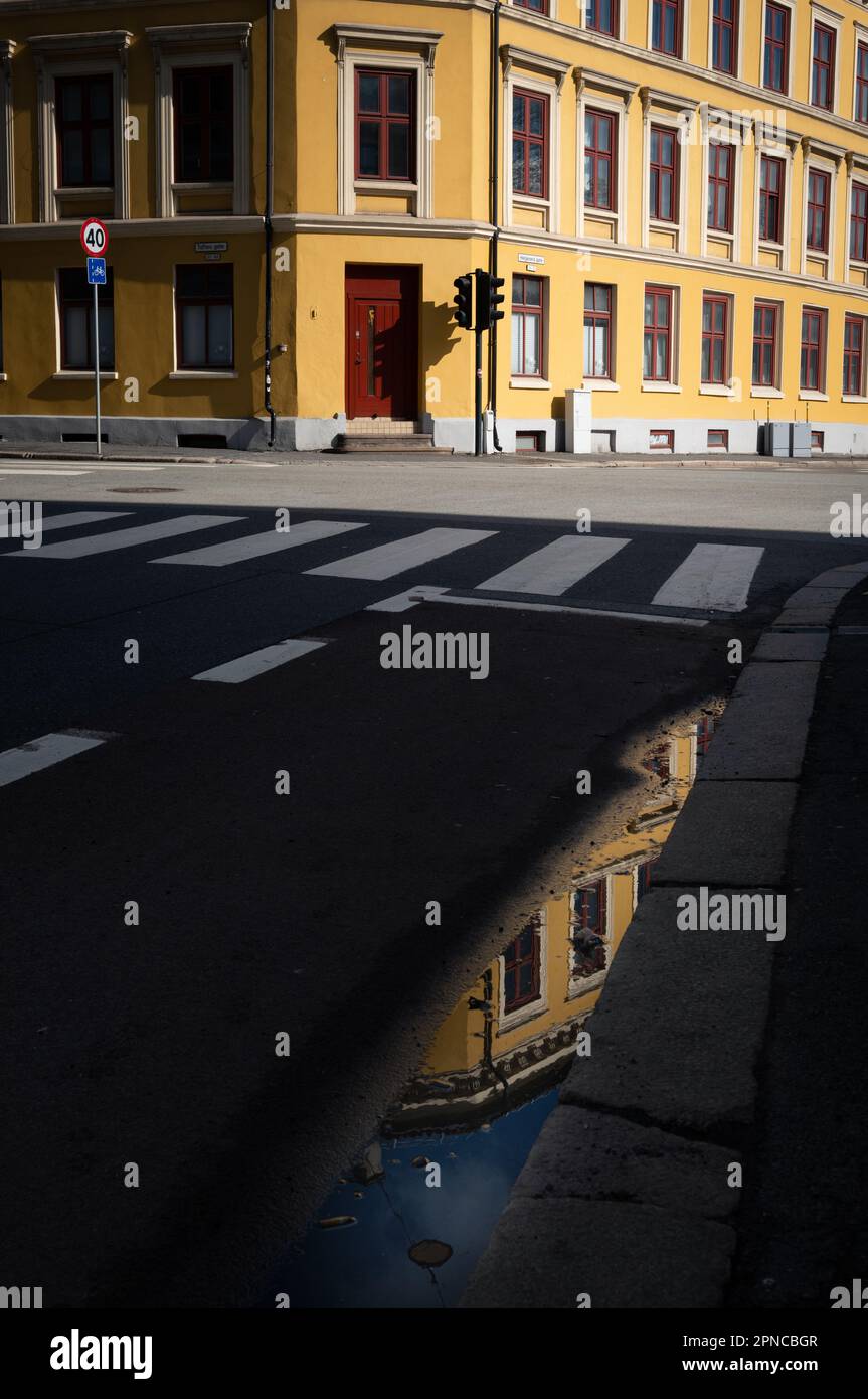 A street-level view of a building, with a reflective pool of water on ...