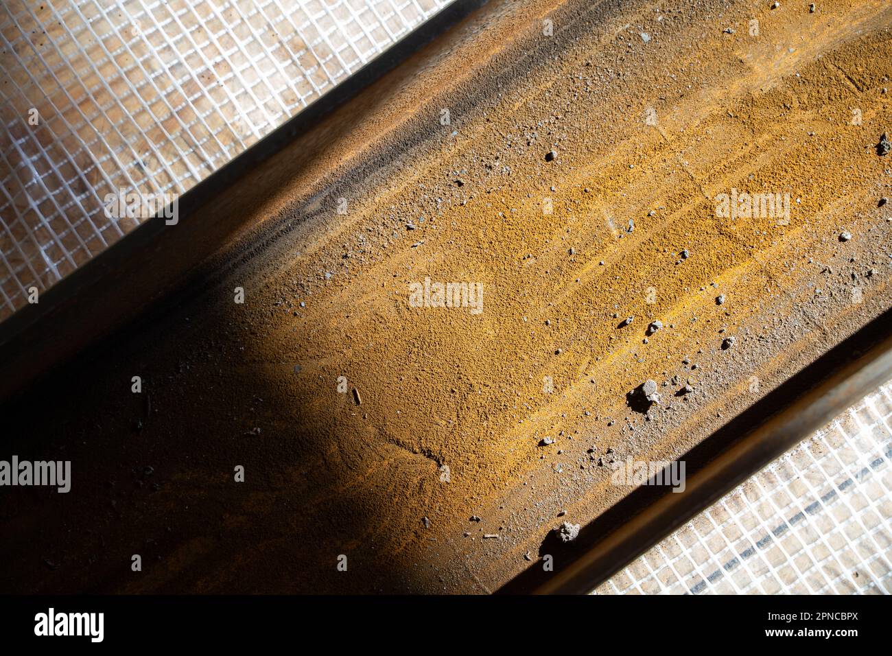 A rusty metal channel close-up lies on a vapor barrier. Surface rust ...