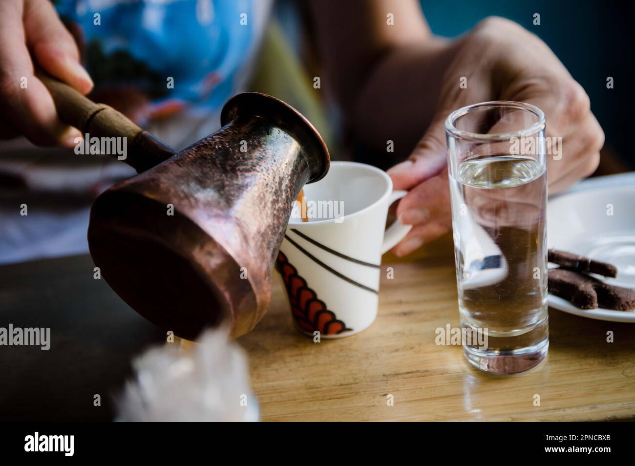 Person hands pouring traditional turkish coffee into a cup during an ...