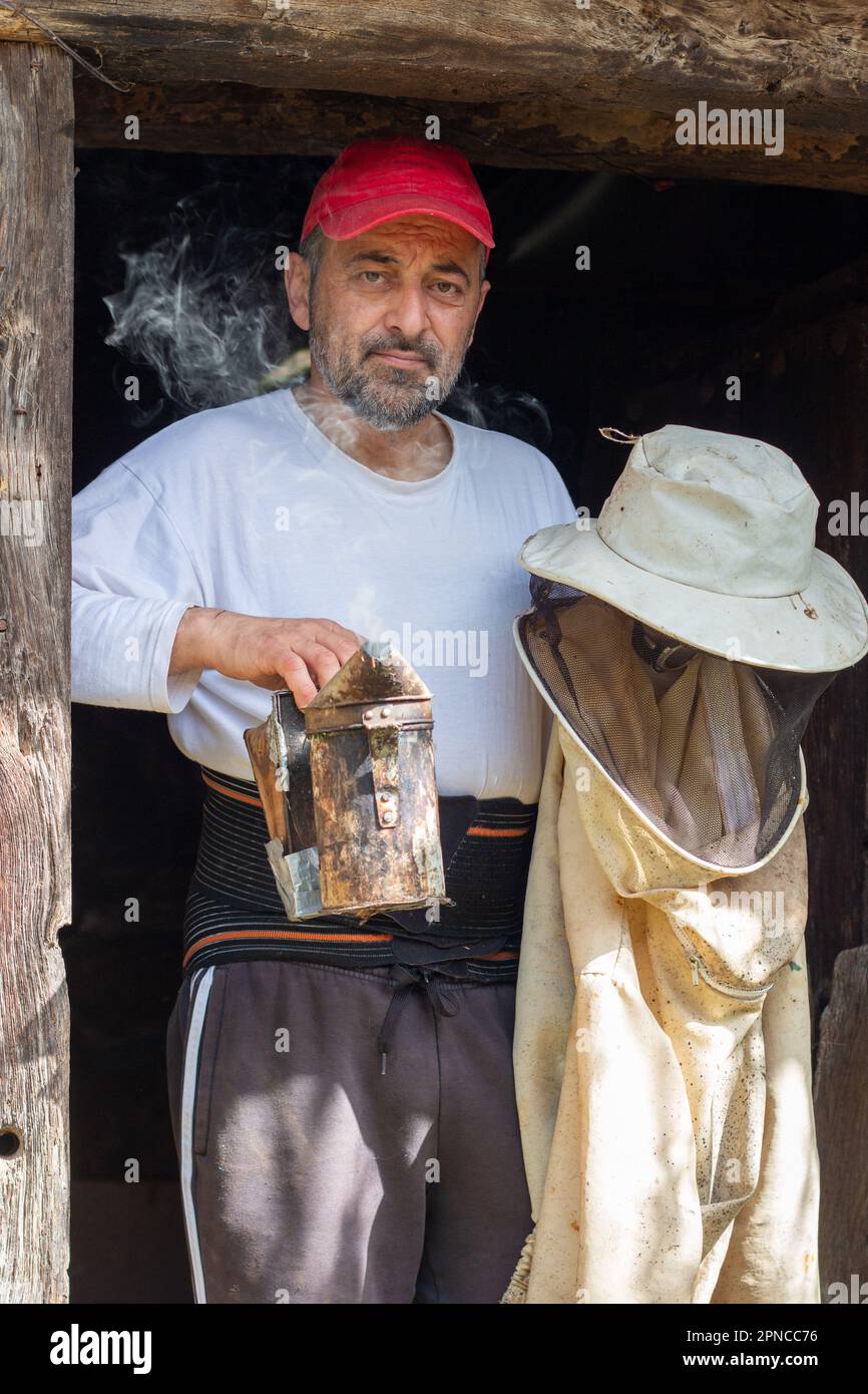 Beekeeping smoker. The beekeeper lighting it with different fuels and ...