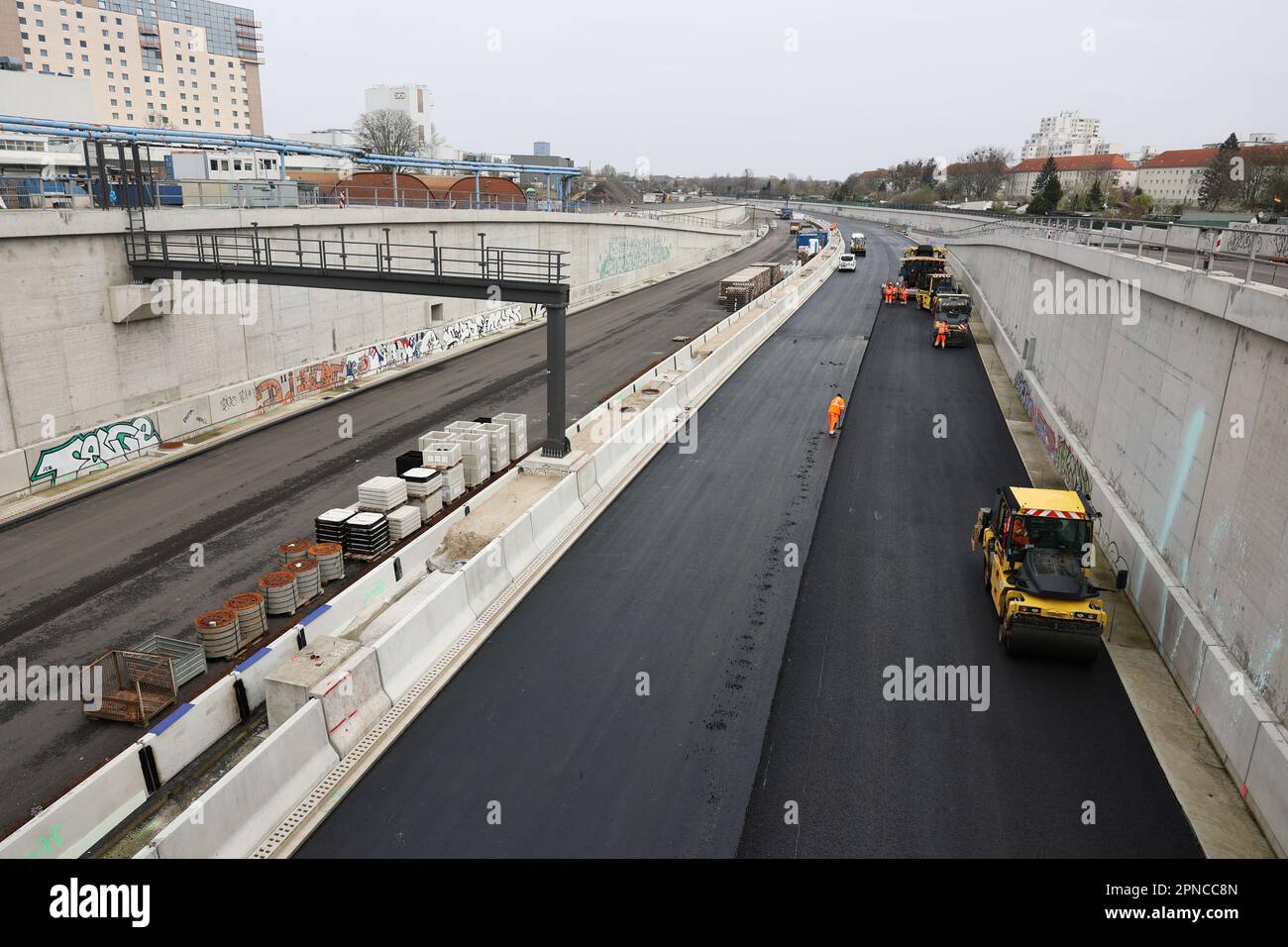 Berlin, Germany. 18th Apr, 2023. A roadway is rolled with a layer of ...