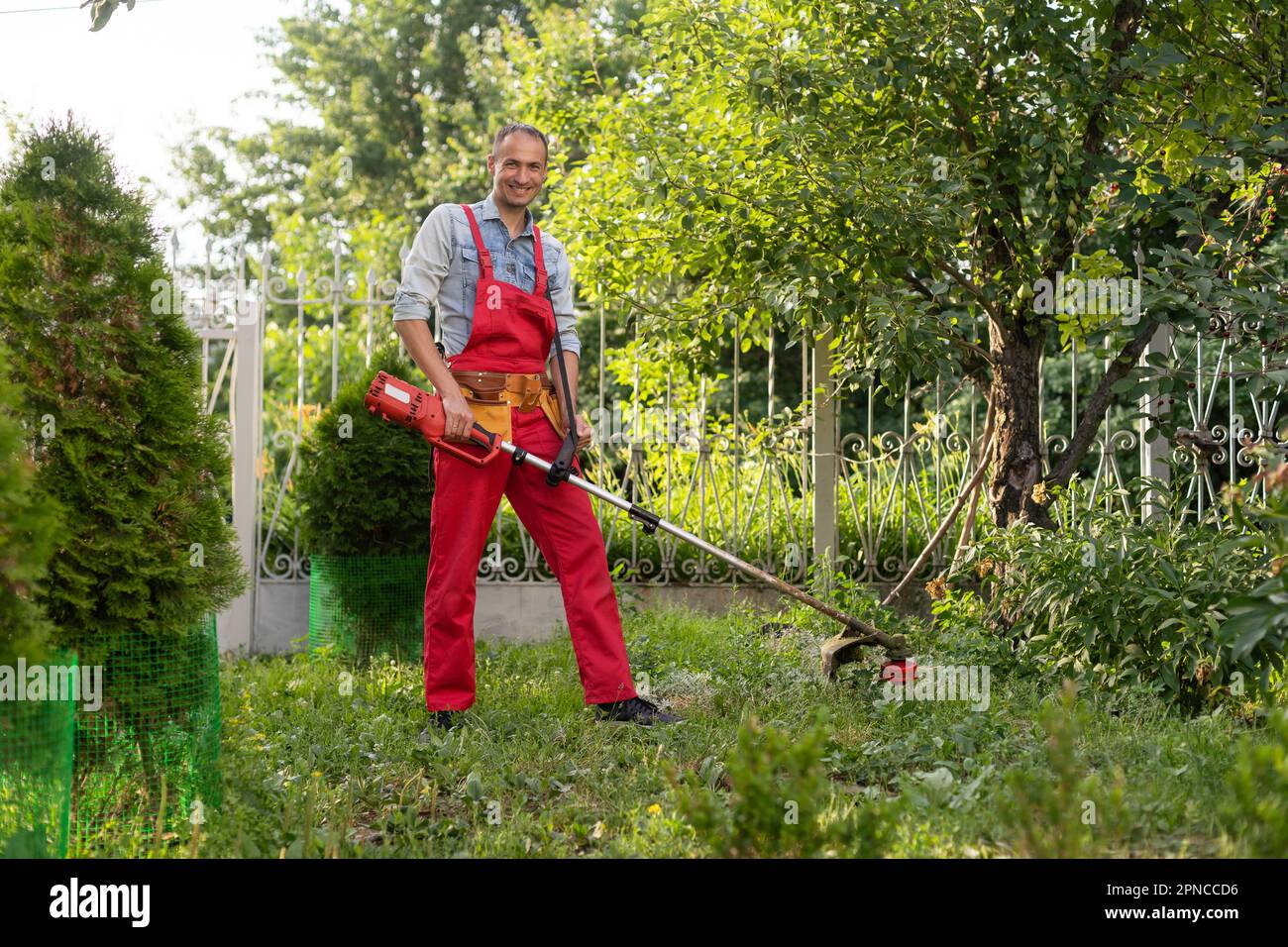 Man worker cutting grass with lawn mower Stock Photo - Alamy