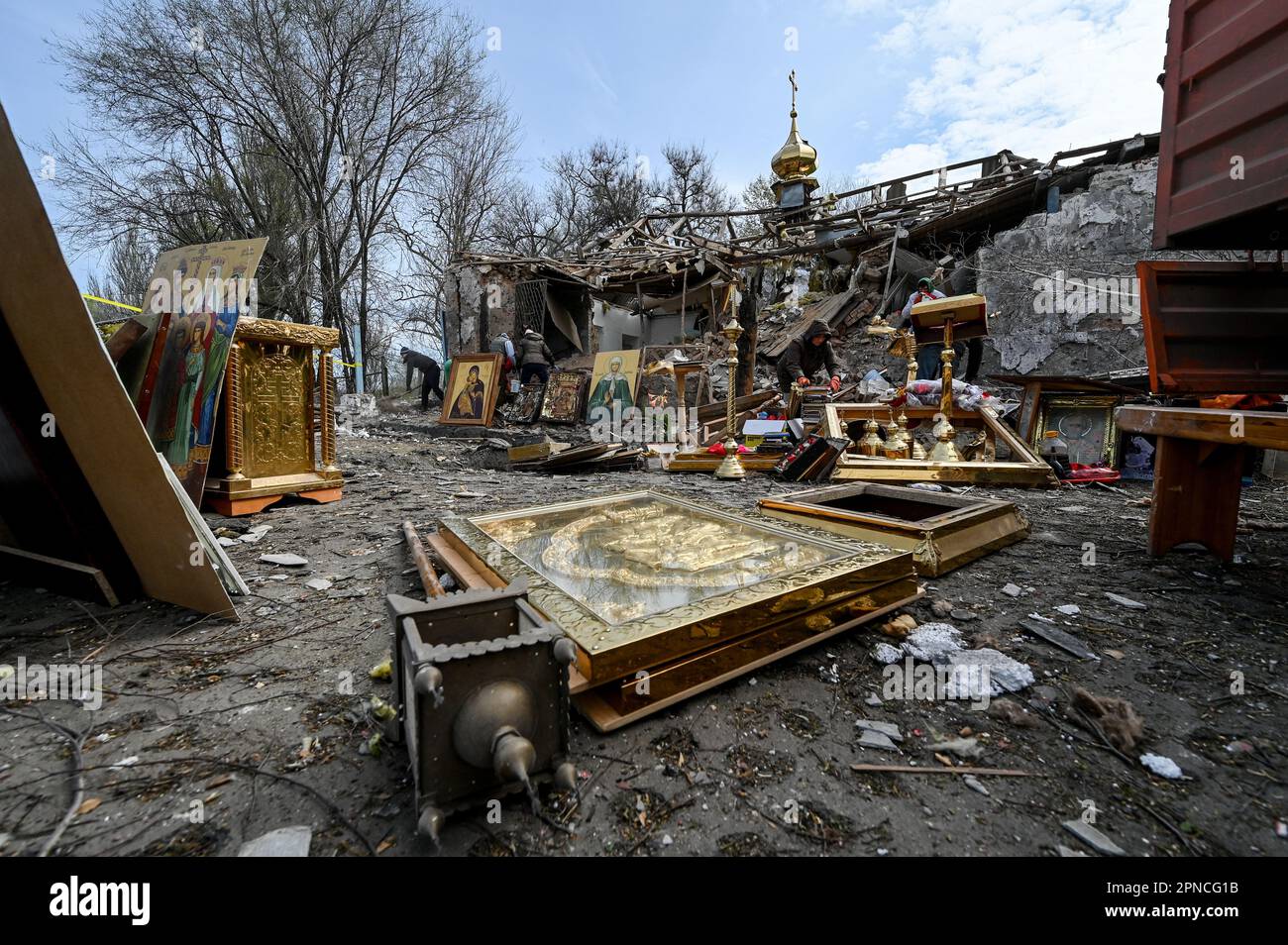 KOMYSHUVAKHA, UKRAINE - APRIL 16, 2023 - People slavage surviving items ...