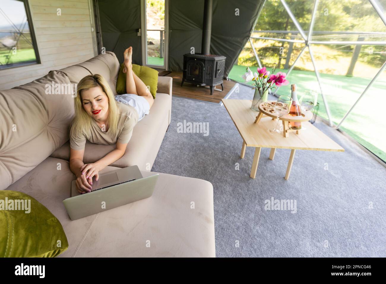 Woman working on laptop geo dome tents. Green, blue background. Cozy, camping, glamping, holiday ...