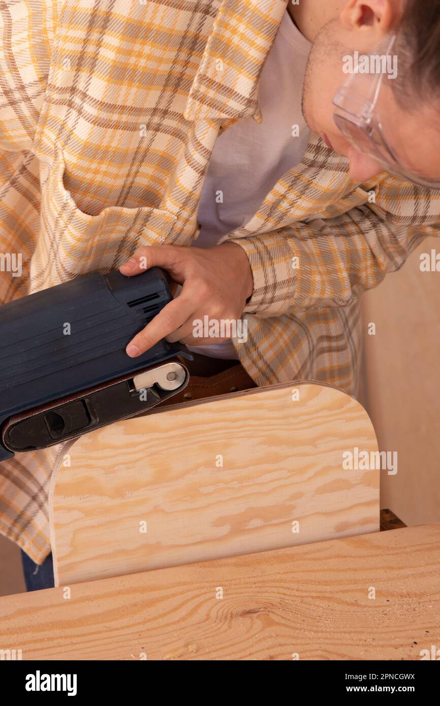 Repairman working with jigsaw in garage. Side view of crop ...