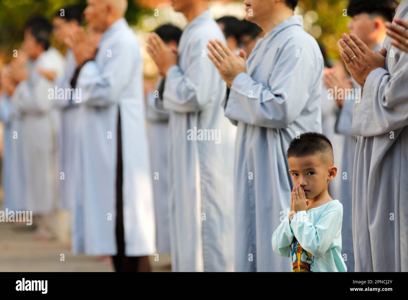 Quan Am Bo Tat temple. Buddhist ceremony. Young child praying. Vung Tau ...